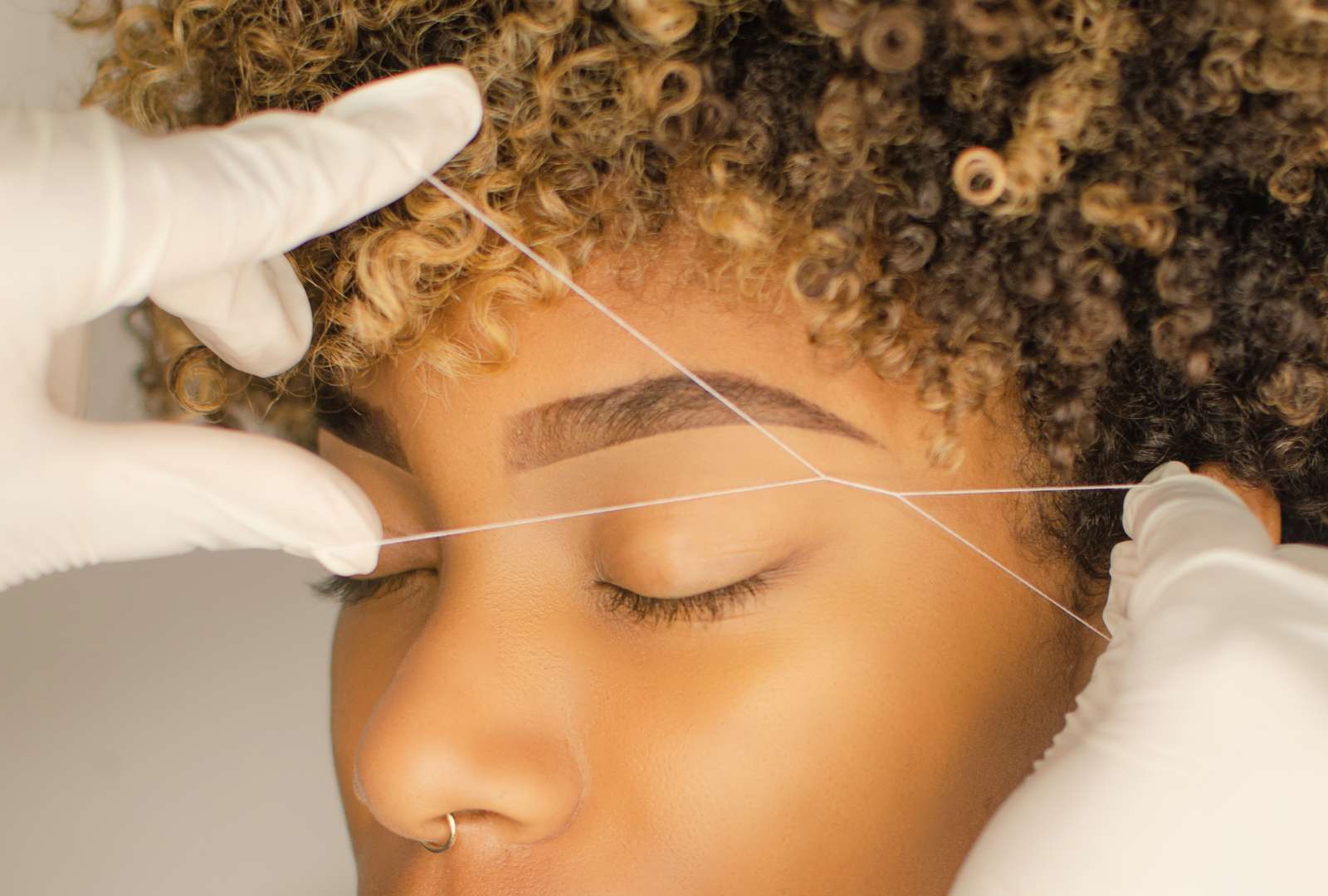 Depilación con un hilo para cejas y rostro